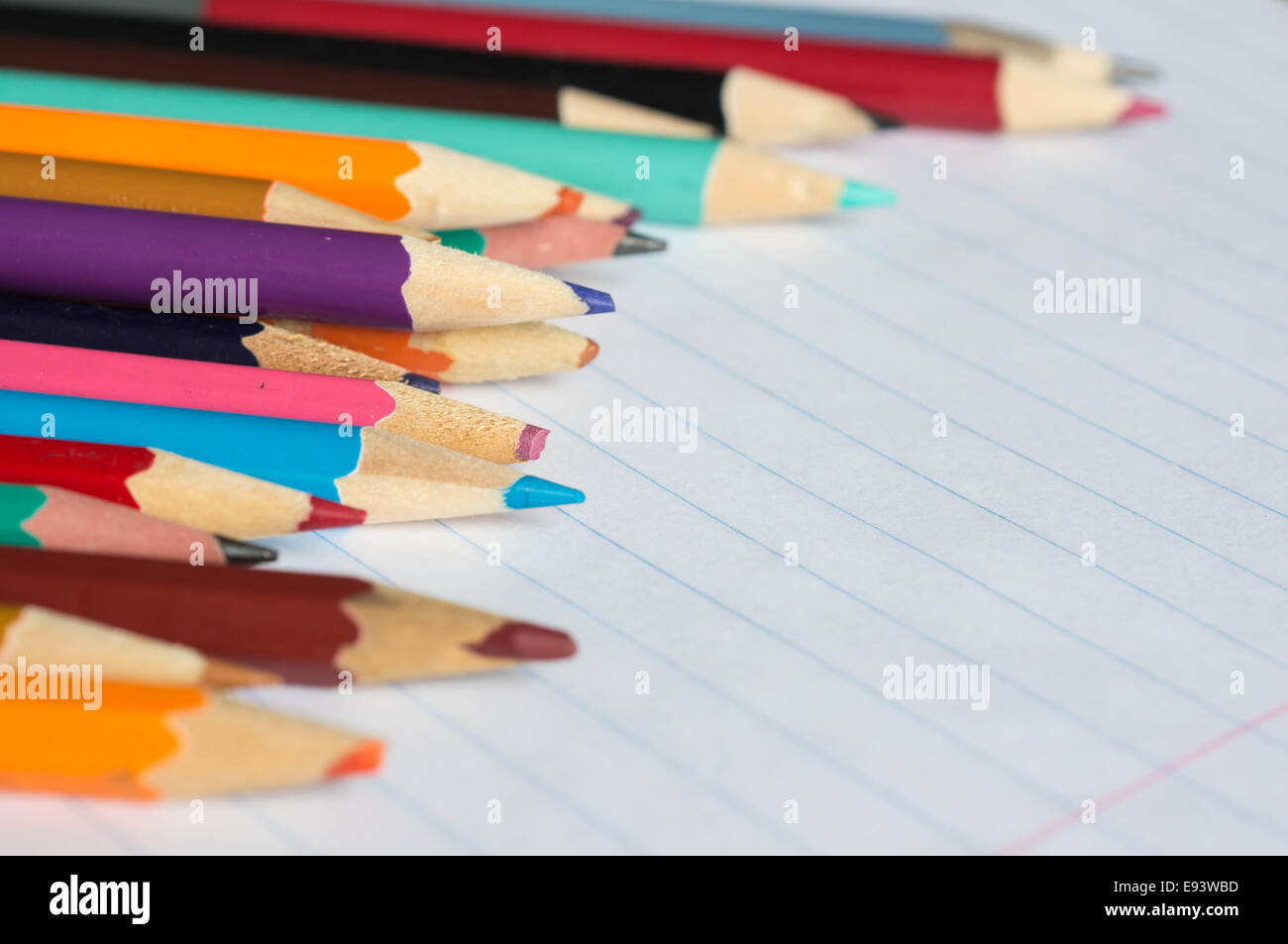 The multi-colored pencils lying on the writing-book page Stock Photo ...
