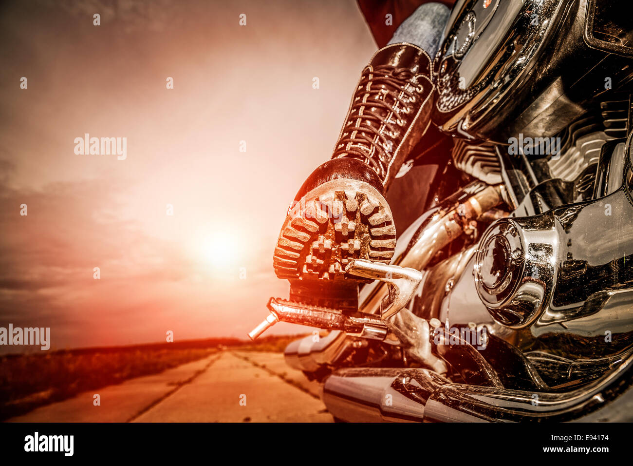 Biker girl riding on a motorcycle. Bottom view of the legs in leather ...