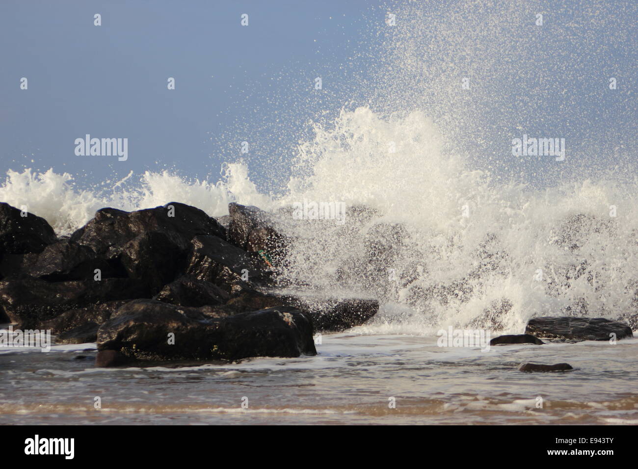 Crashing waves against black rocks at coast Stock Photo - Alamy