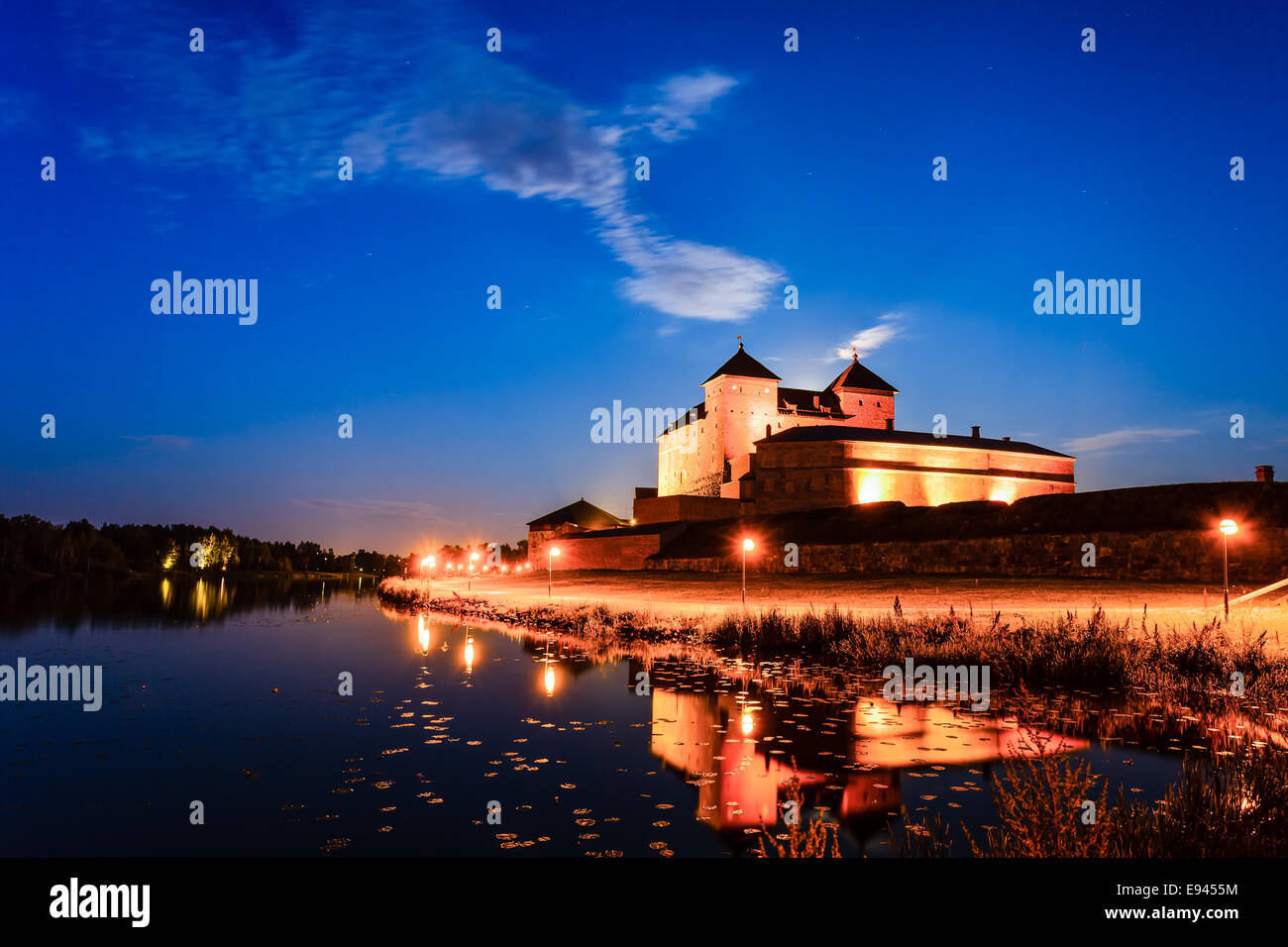Medieval castle at night. Big blue sky above the castle and reflection ...