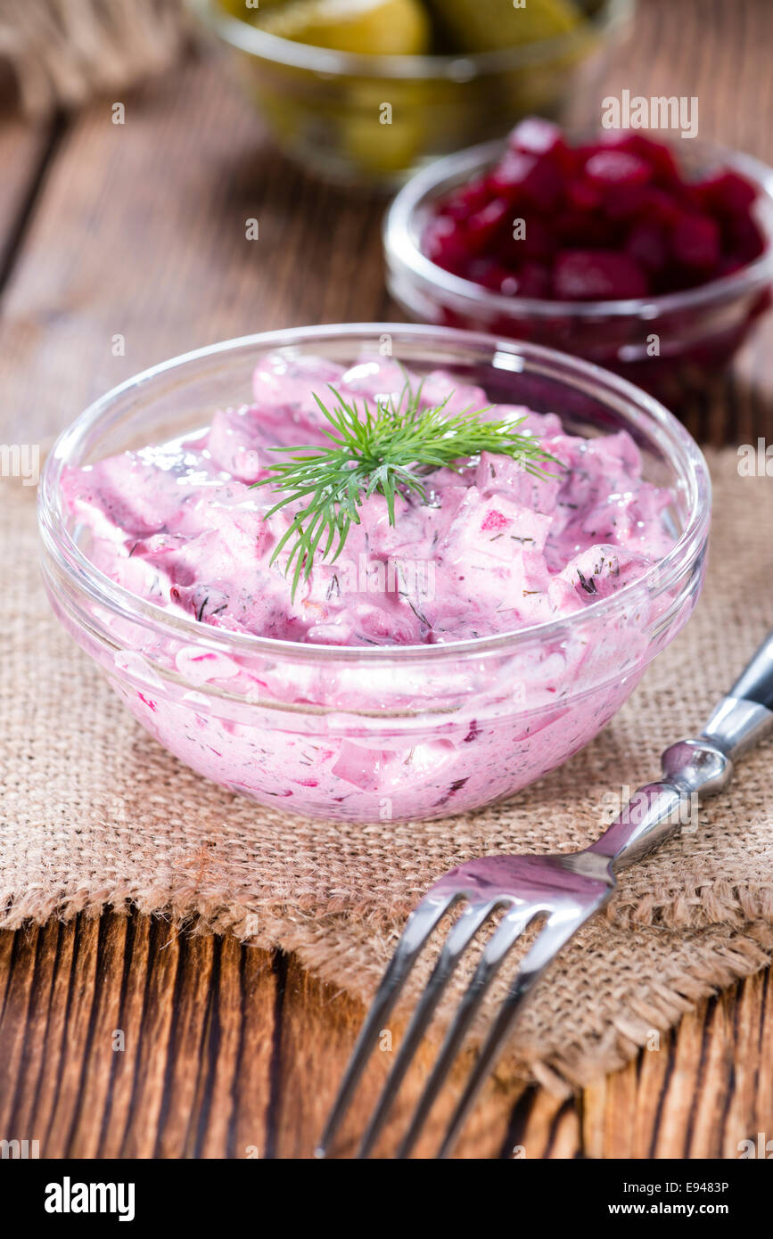 Portion of homemade Herring Salad (with beet) on wooden background ...