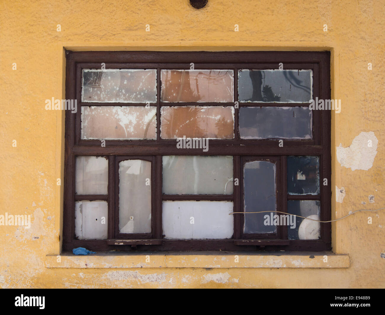 Old weathered window with 14 rectangular window panes subdued colour ...