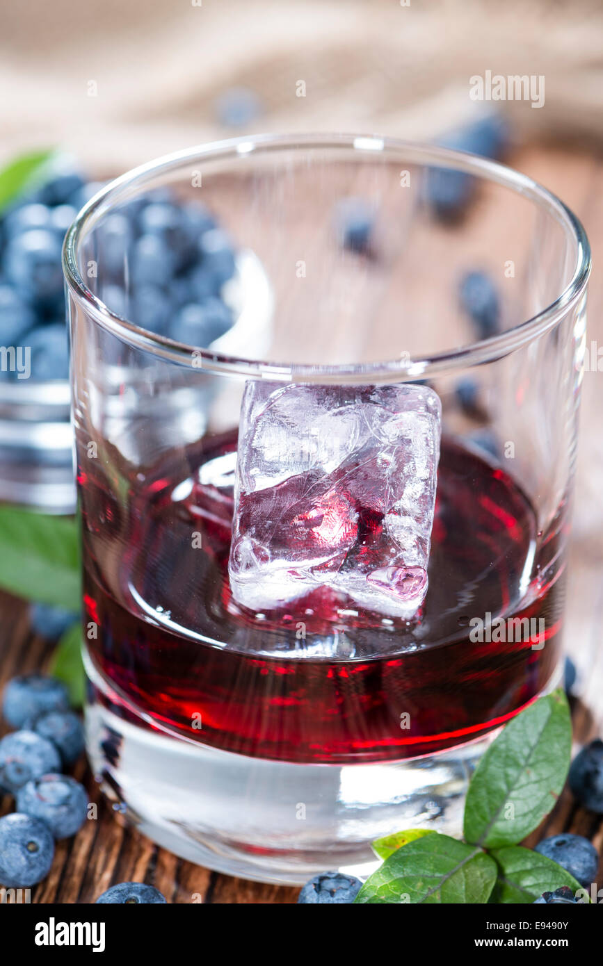 Blueberry Liqueur with some fresh fruits in a small glass Stock Photo ...