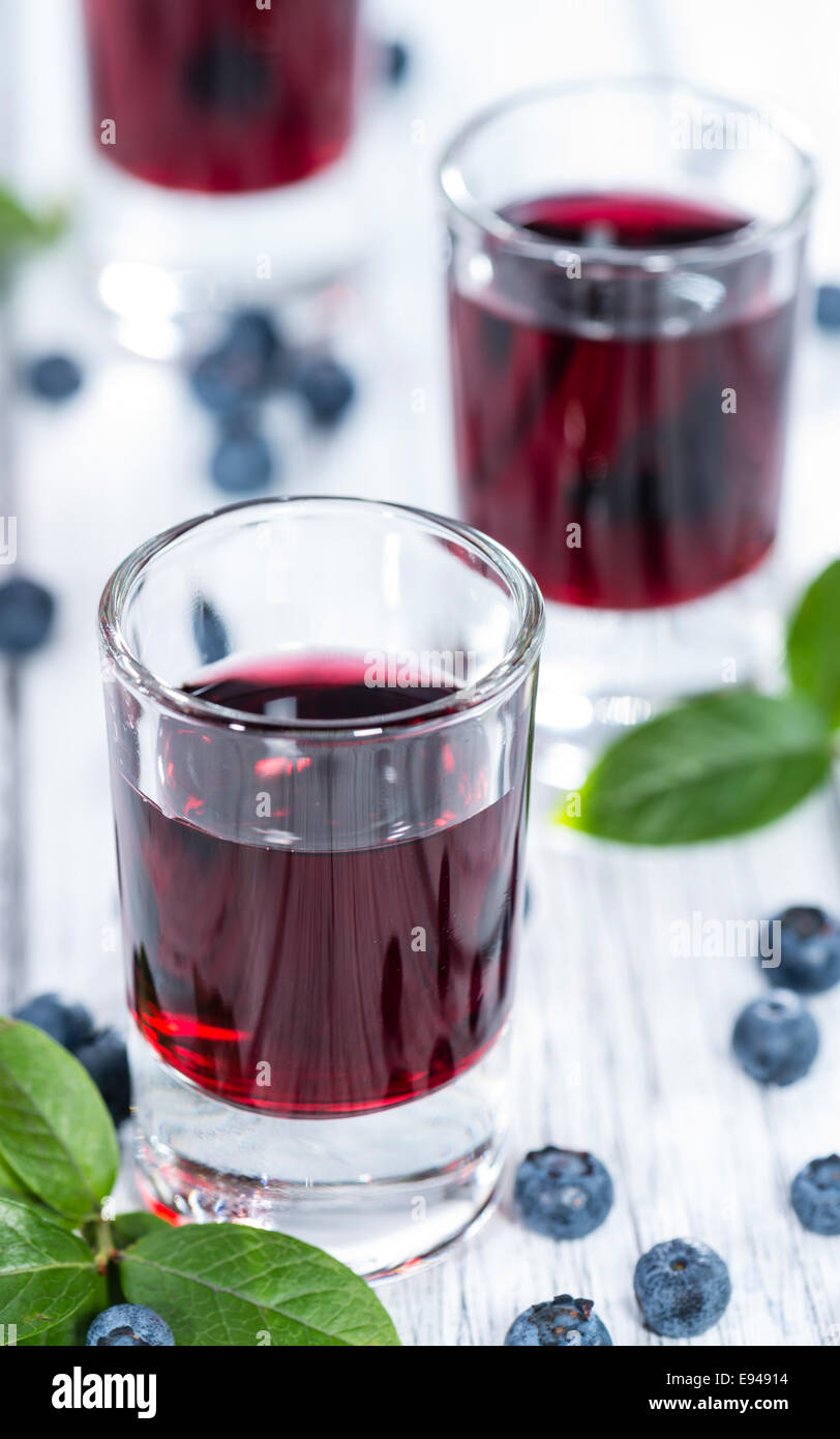 Blueberry Liqueur with some fresh fruits in a small glass Stock Photo ...