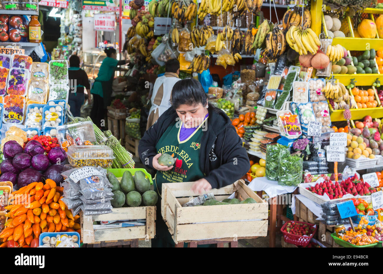 Local Peruvian woman stallholder at a colourful fruit and vegetable ...
