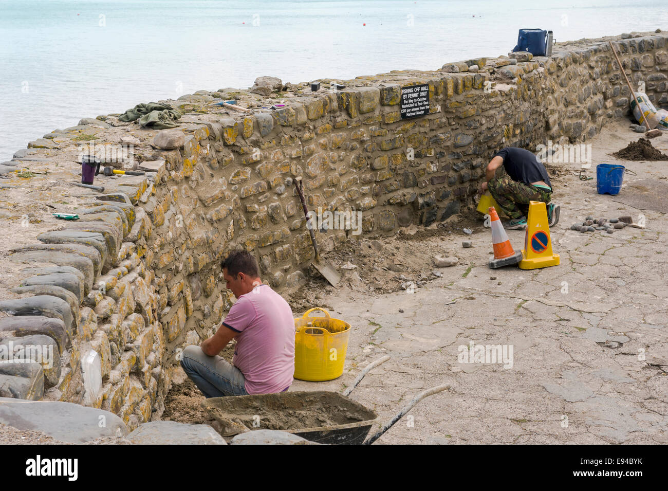 Workmen maintaining the harbour Stock Photo - Alamy
