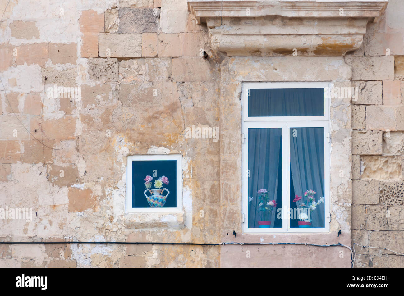 A large and small window with flowers in Valletta, the capital of Malta ...
