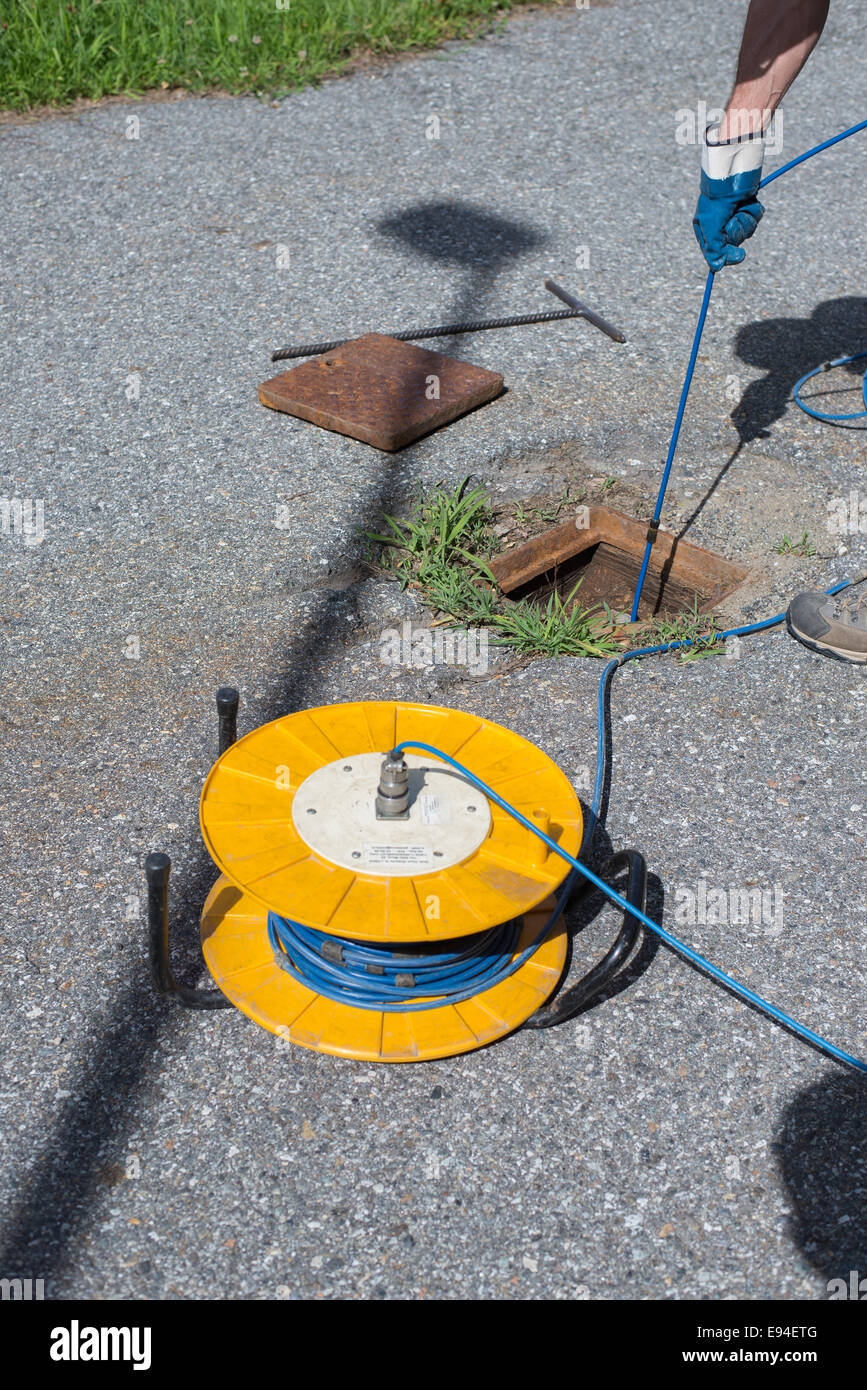 Geologist taking inclinometer readings on road, measuring slope ...