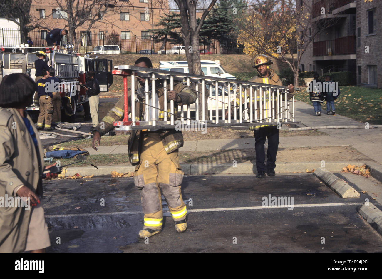firefighters carrying a ladder Stock Photo - Alamy