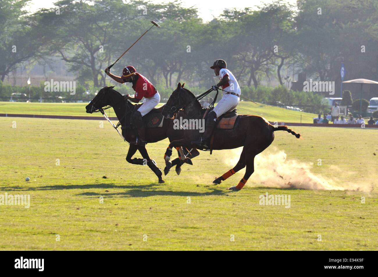 Polo players galloping across the field Stock Photo - Alamy
