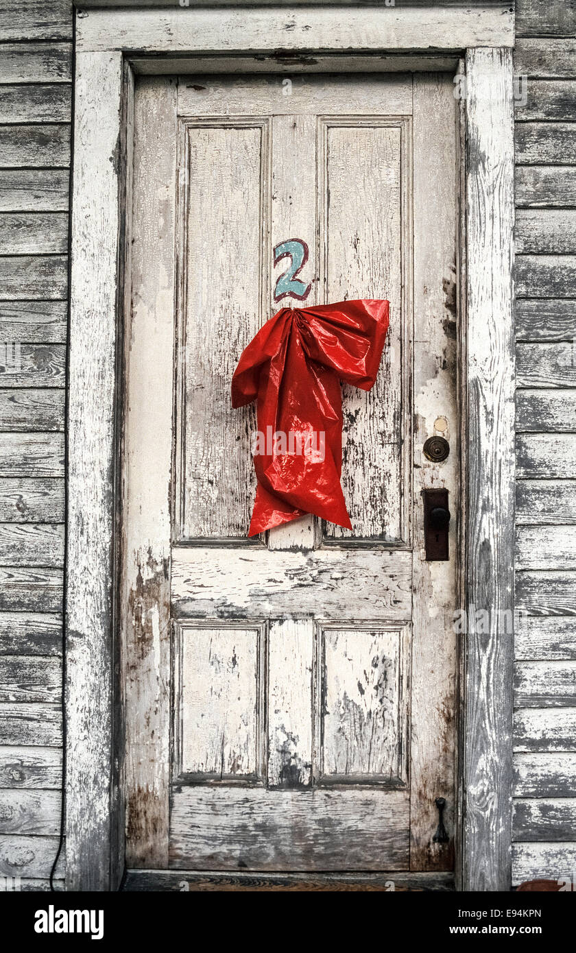 A sagging red plastic Christmas bow makes an unsuccessful attempt to ...