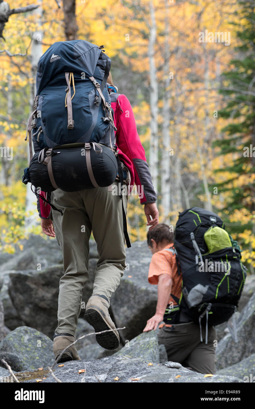 Backpackers walking on a talus slope in Oregon's Wallowa Mountains ...
