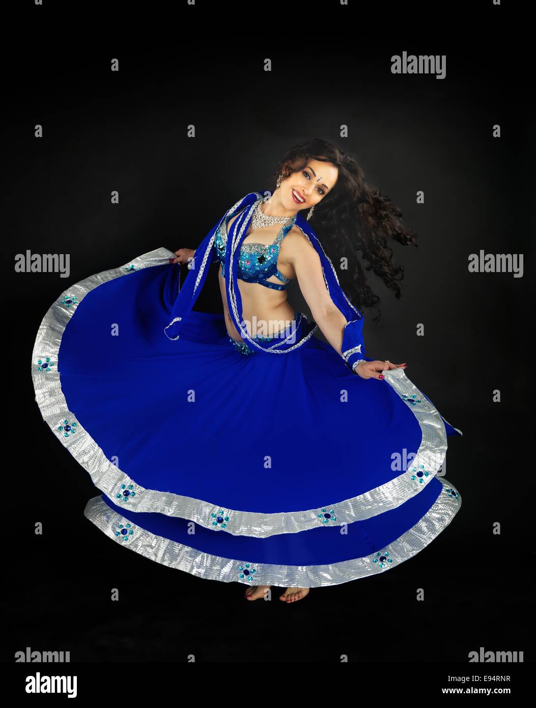Young beautiful belly dancer wearing dark blue costume in front of the ...