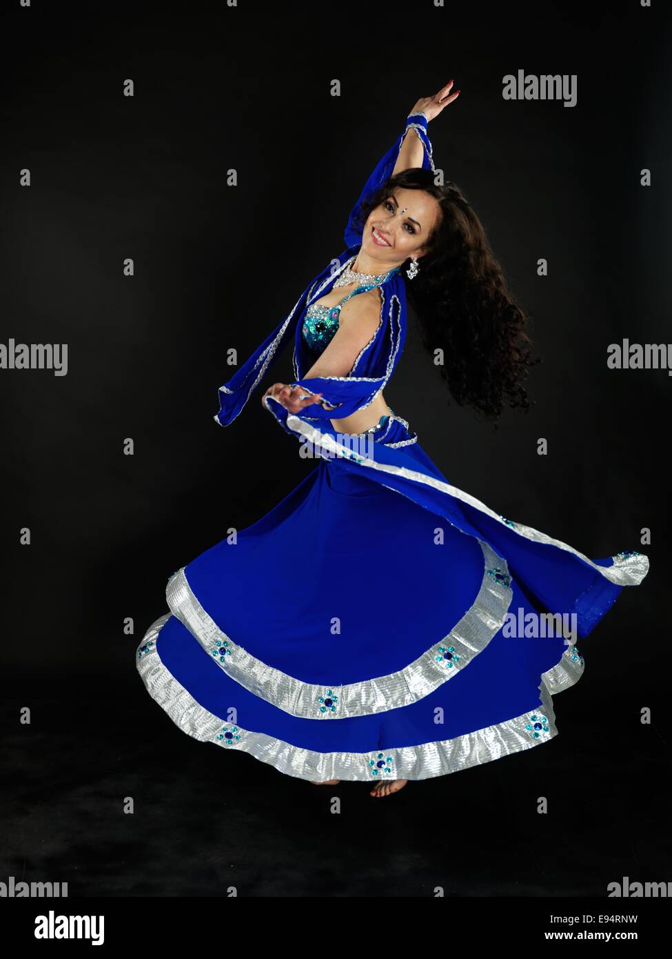 Young beautiful belly dancer wearing dark blue costume in front of the ...