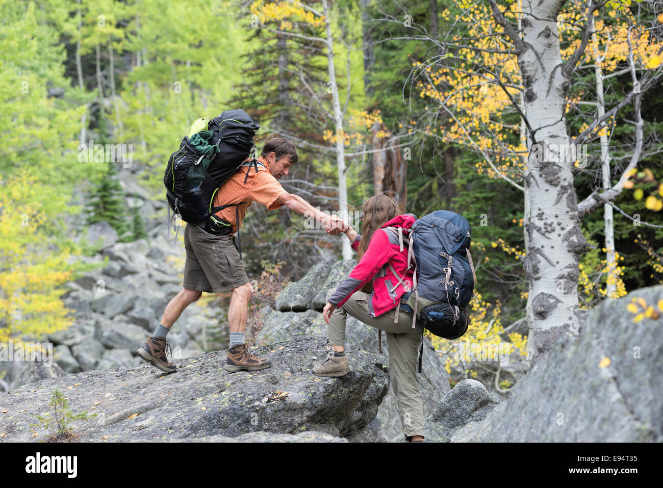 Backpackers walking on a talus slope in Oregon's Wallowa Mountains ...