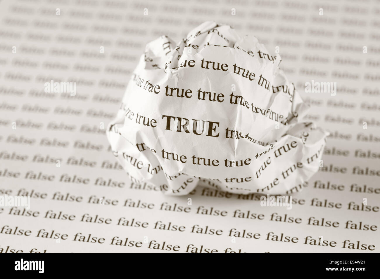 Crumpled paper ball with words "True" on background with words "false ...