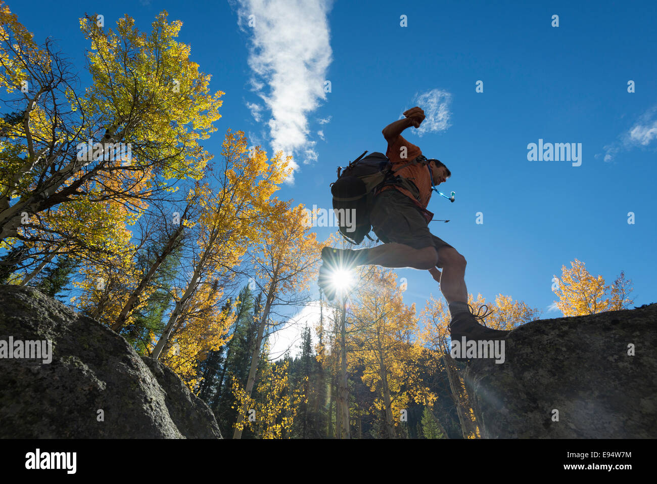 Backpacker leaping from boulder to boulder on a talus slope in Oregon's ...