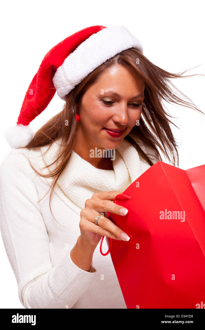 Happy vivacious Christmas shopper wearing a red Santa hat holding up a ...