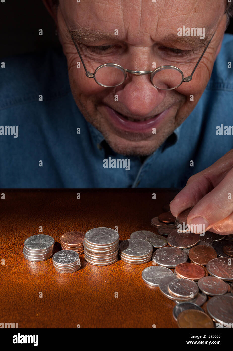 Senior man counting cash into piles Stock Photo - Alamy