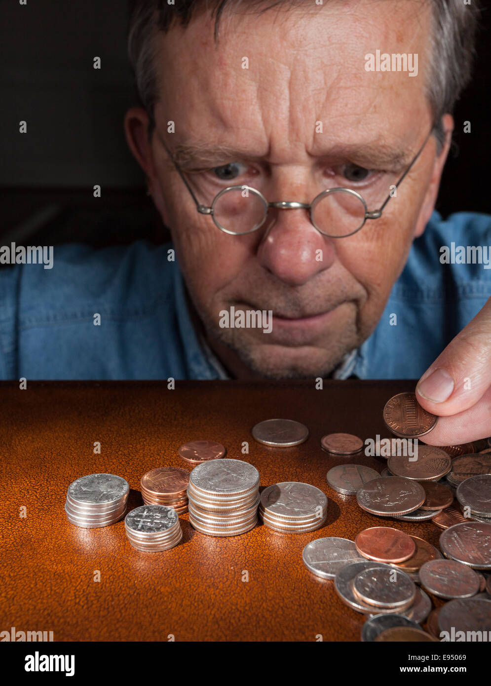 Senior man counting cash into piles Stock Photo - Alamy