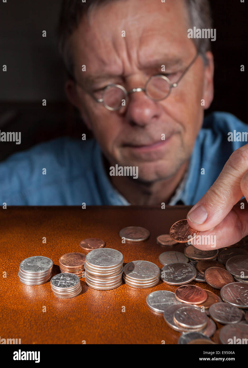 Senior man counting cash into piles Stock Photo - Alamy