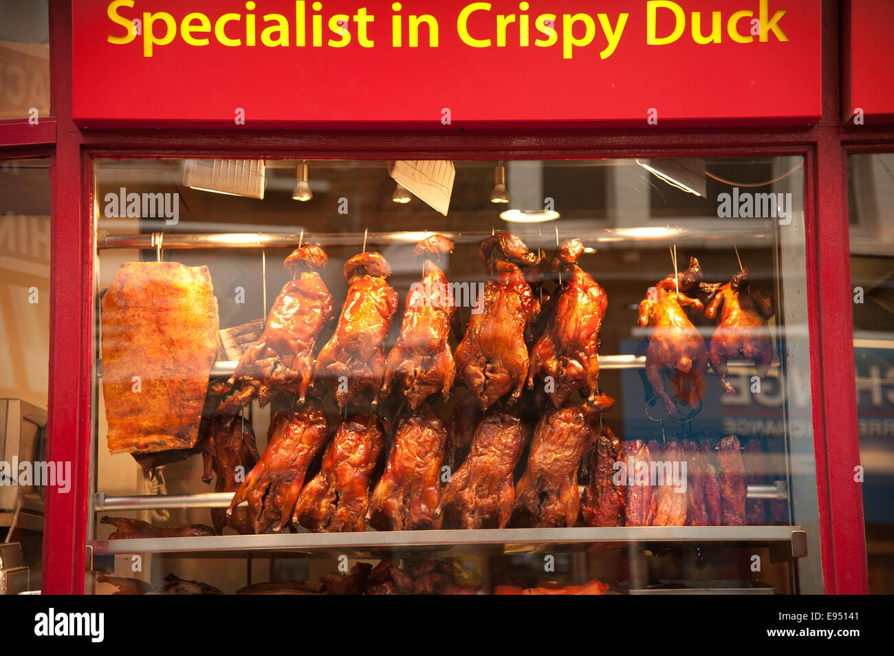 Reflections of streets and rows of crispy roasted succulent duck ready ...