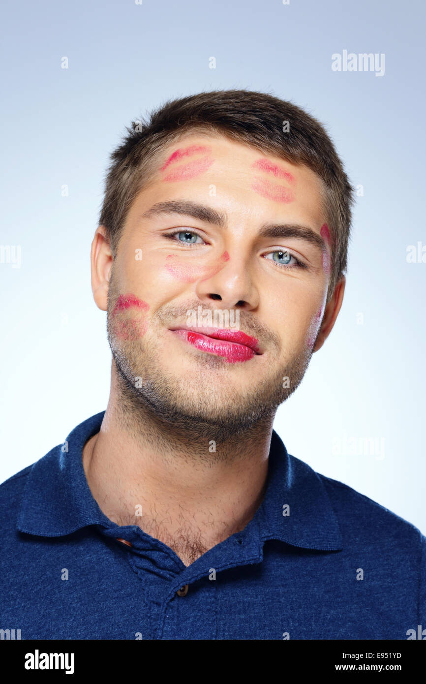 Portrait of young man with face full of lipstick marks of kisses Stock ...