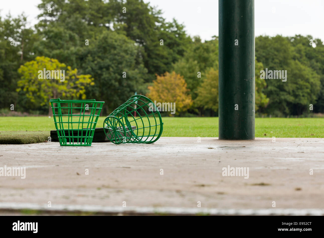 Two Empty Golf Ball Baskets at Driving Range with Hole and Flag in ...