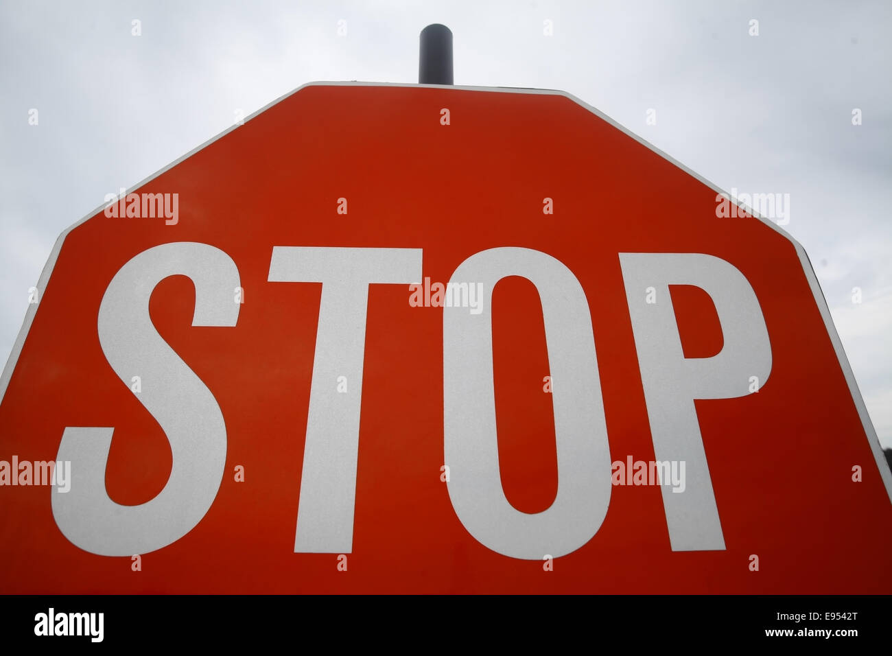 Color detail of a red "STOP" sign at a road junction Stock Photo - Alamy