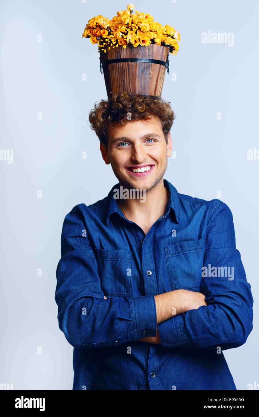 Happy man with a bucket on his head with flowers Stock Photo - Alamy