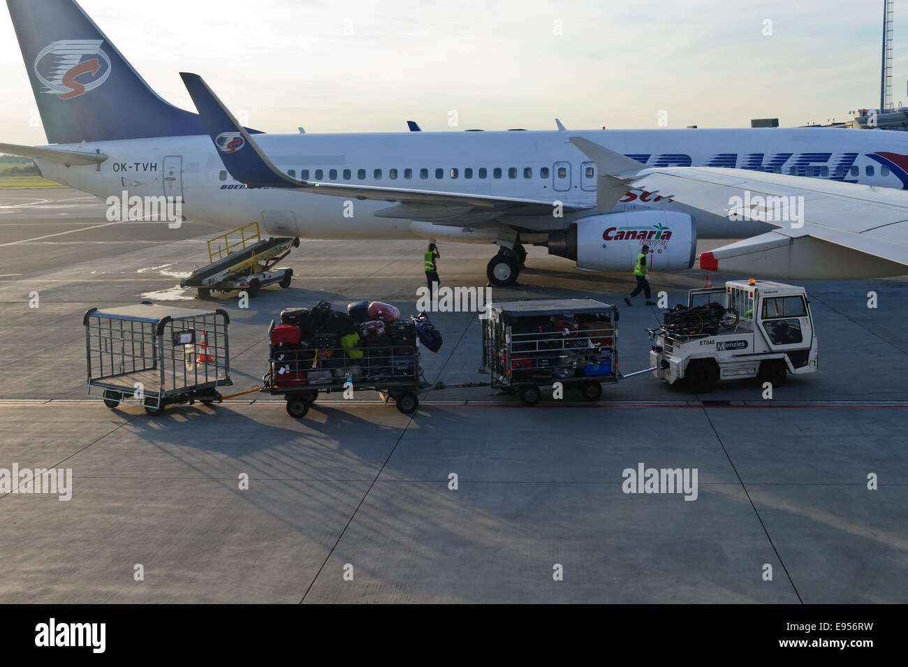 A motorized cart loaded with passengers luggages moving away from an ...
