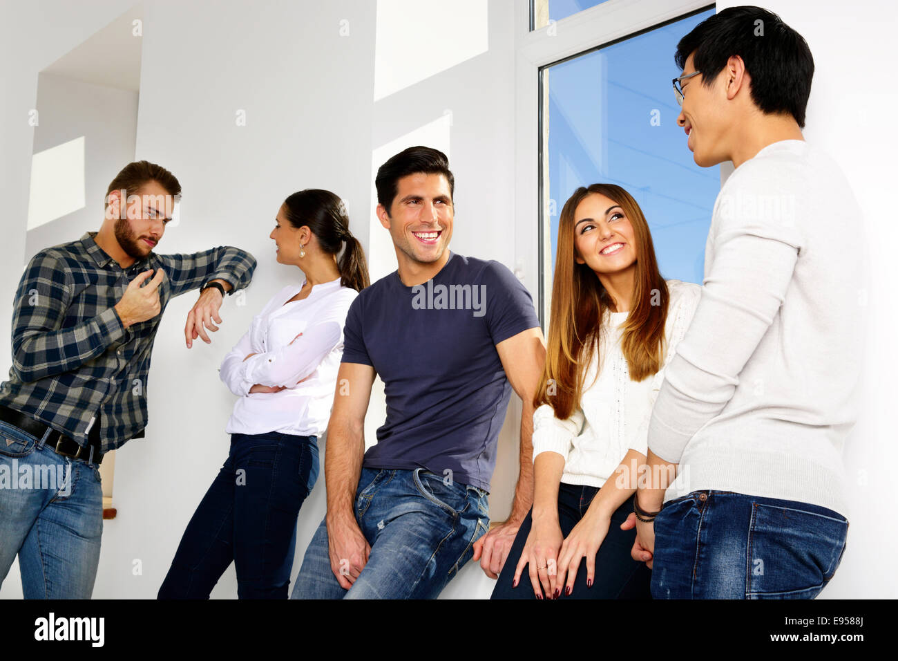 Portrait of a happy group of people talking in hallway Stock Photo - Alamy