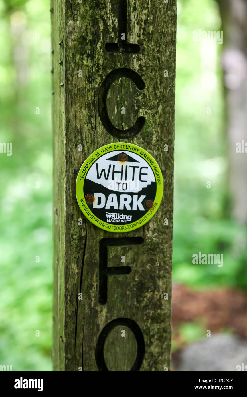 A sign disc on a public footpath post saying white to dark which is the ...