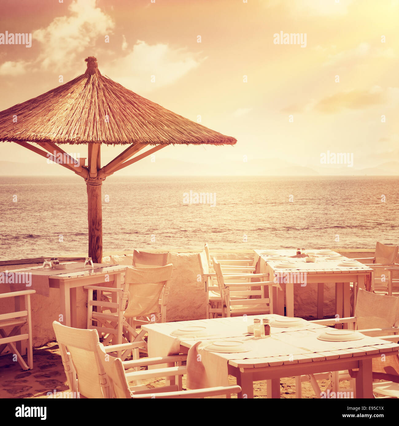 Cozy restaurant on the beach in mild sunset light, romantic dinner on ...