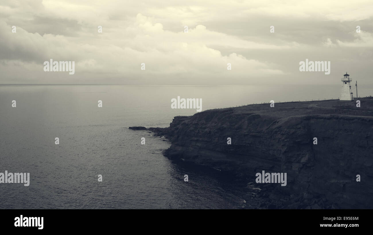 A lonely lighthouse protecting the coastline on the steep shore cliffs ...