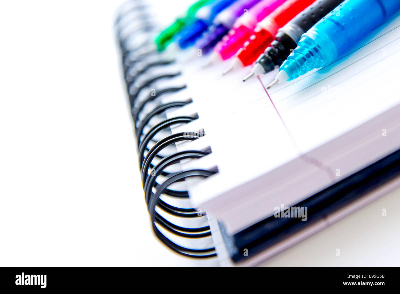 back to school supplies, bright multi colored pens and a spiral ...
