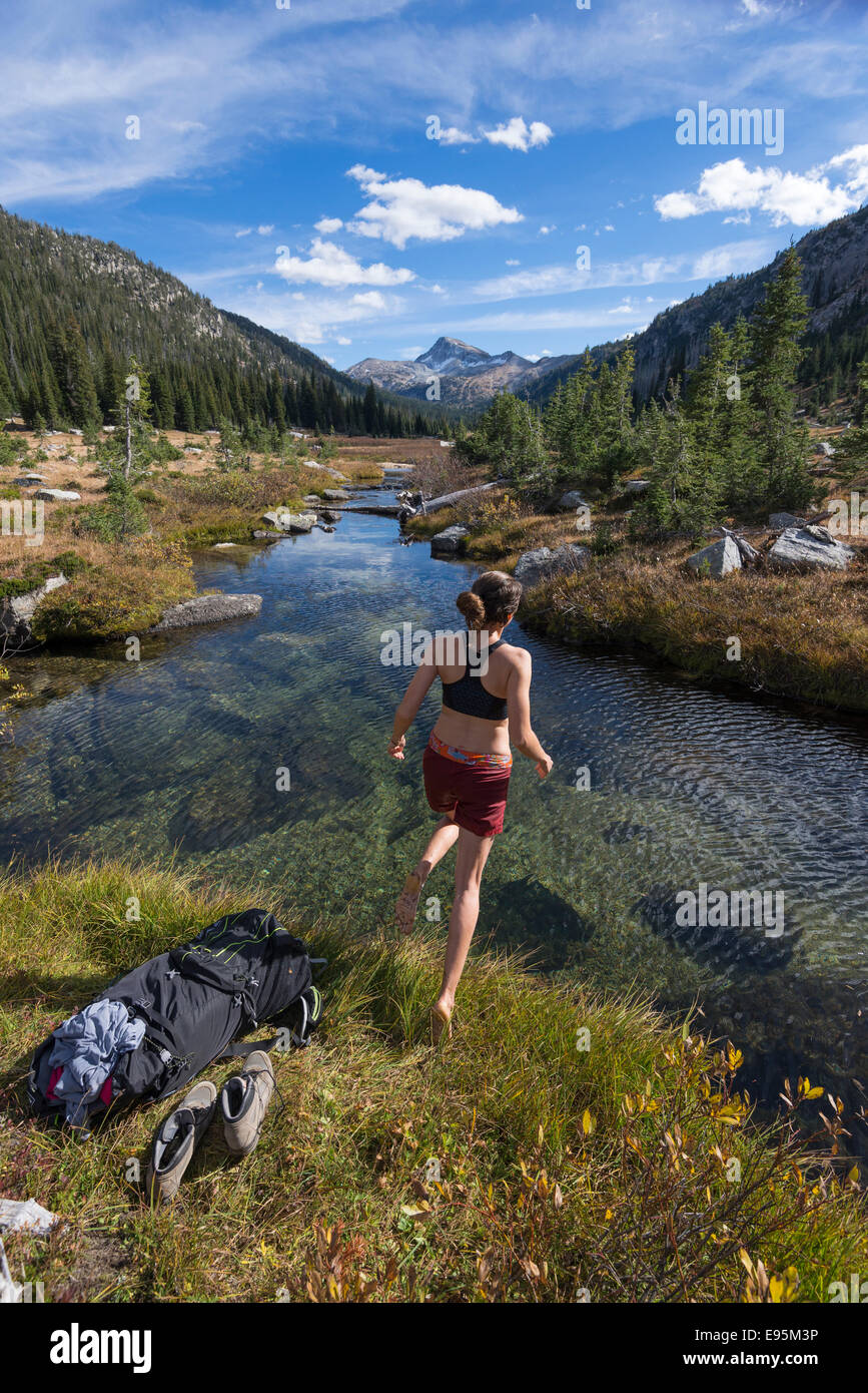 Woman jumping into a stream on a backpack trip in Oregon's Wallowa ...