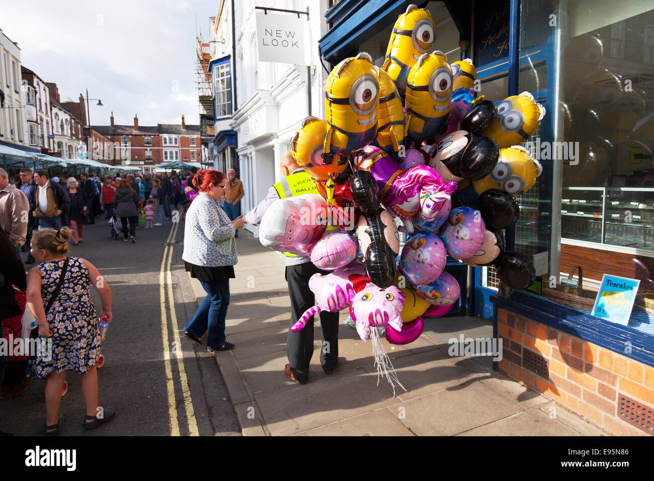 Balloon seller selling balloons to mother for child children helium ...