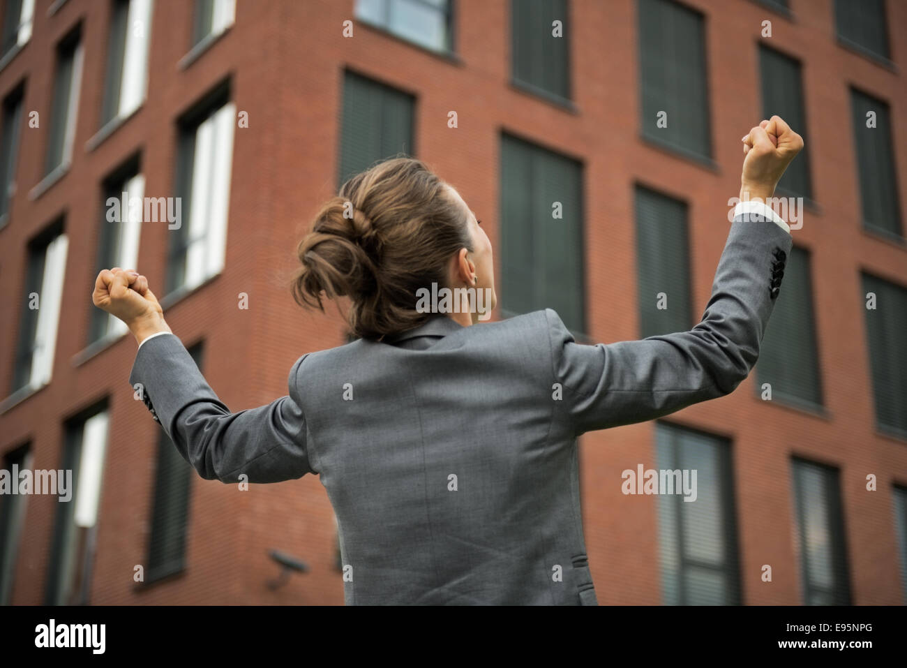 Business woman rejoicing in front of office building. rear view Stock ...