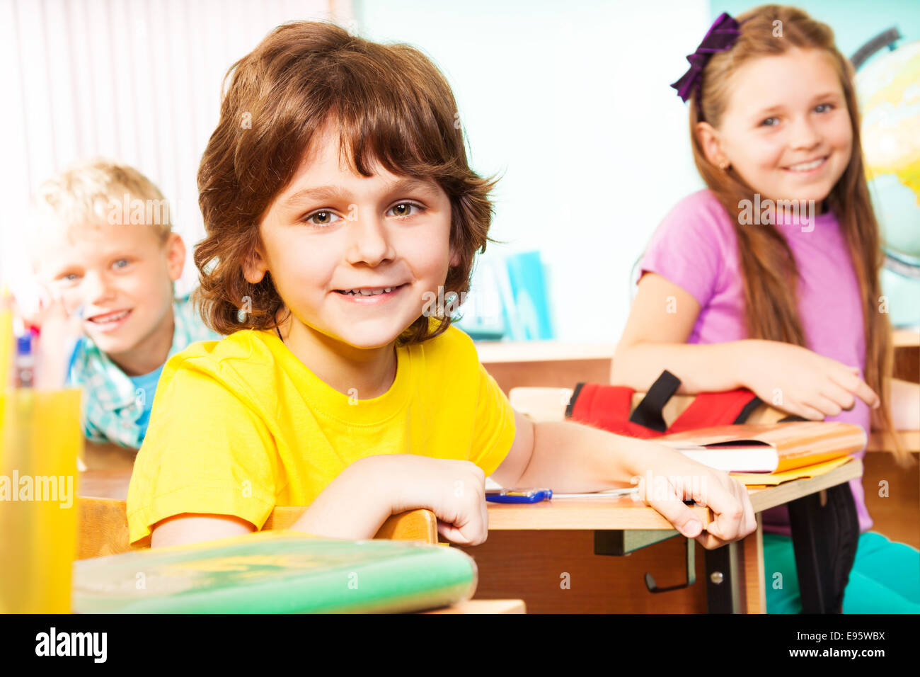 Boy and his classmates look straight, sit at desks Stock Photo - Alamy