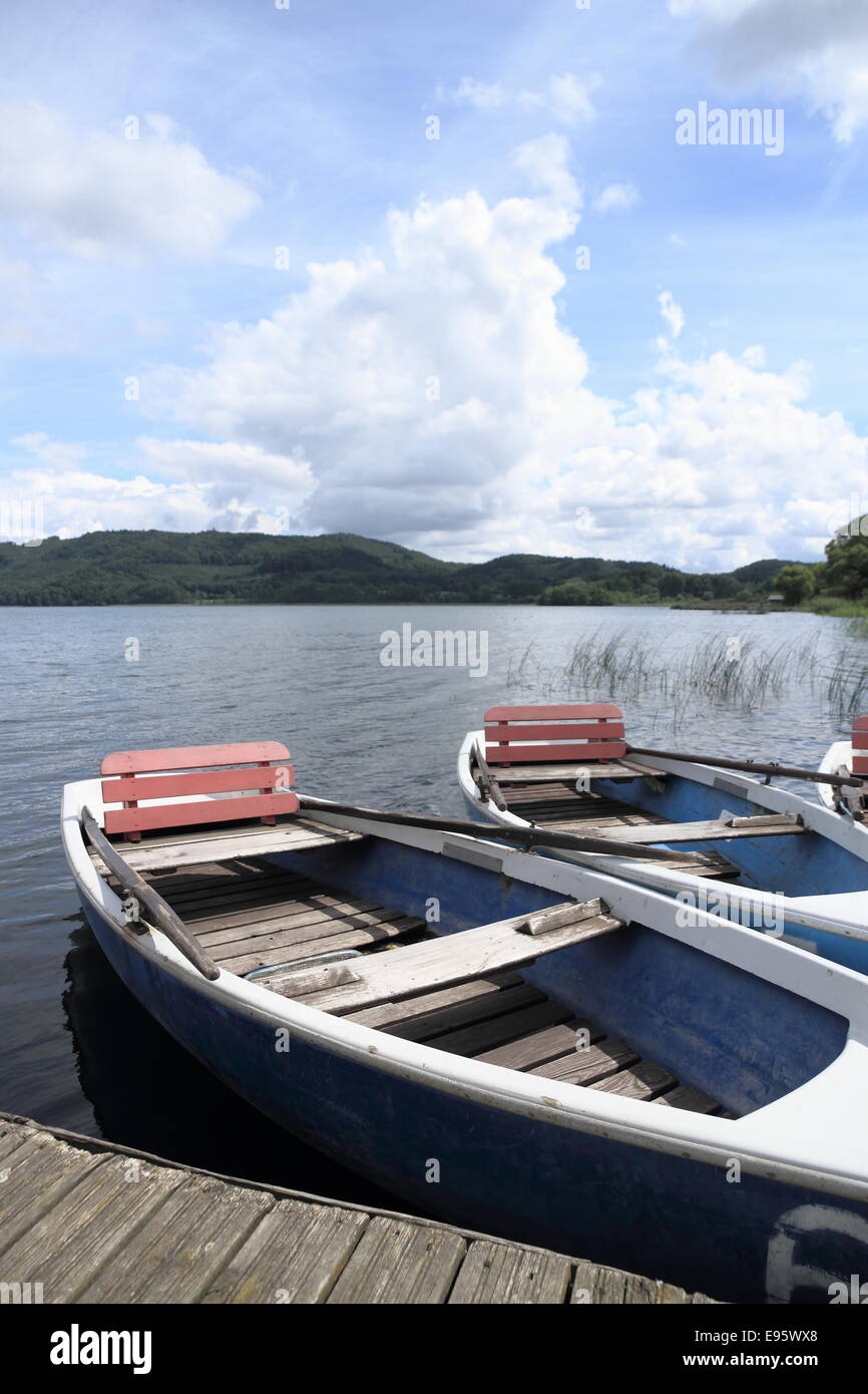 Two row boats at pier on lake as background Stock Photo - Alamy
