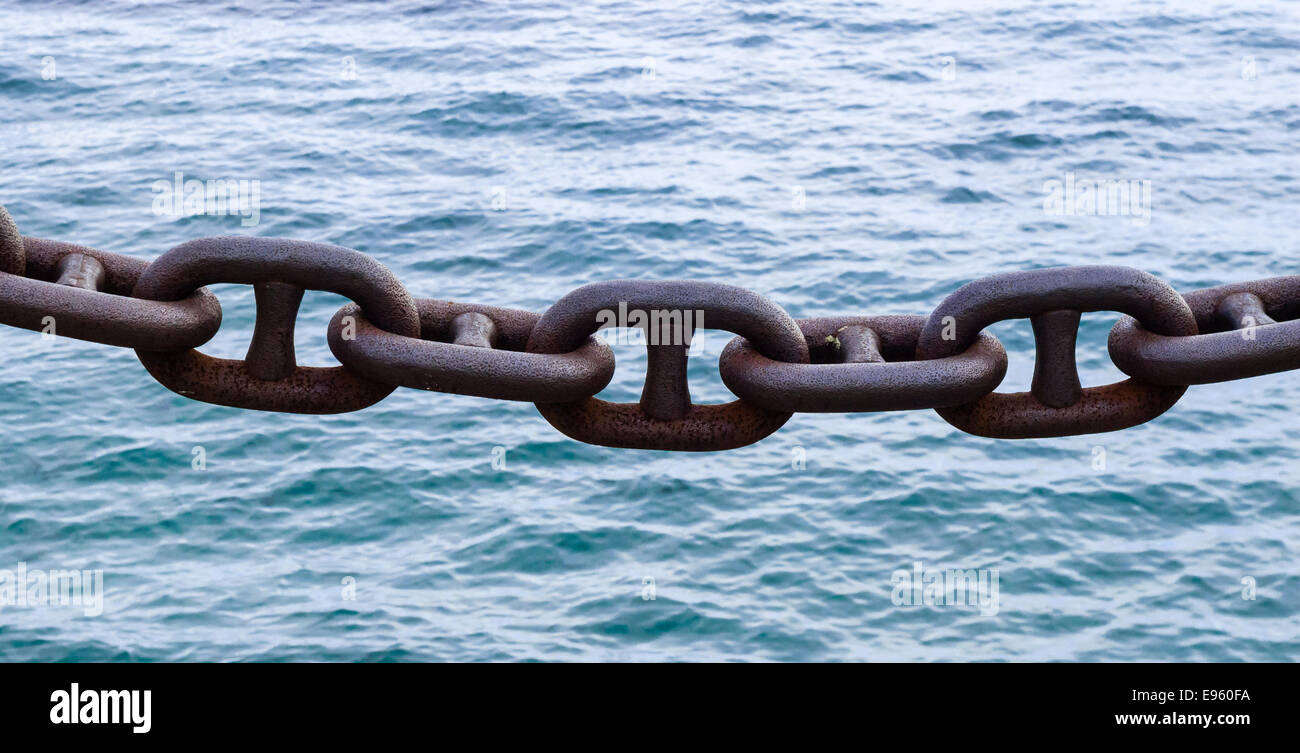Large steel brown rusted chain links against water Stock Photo - Alamy