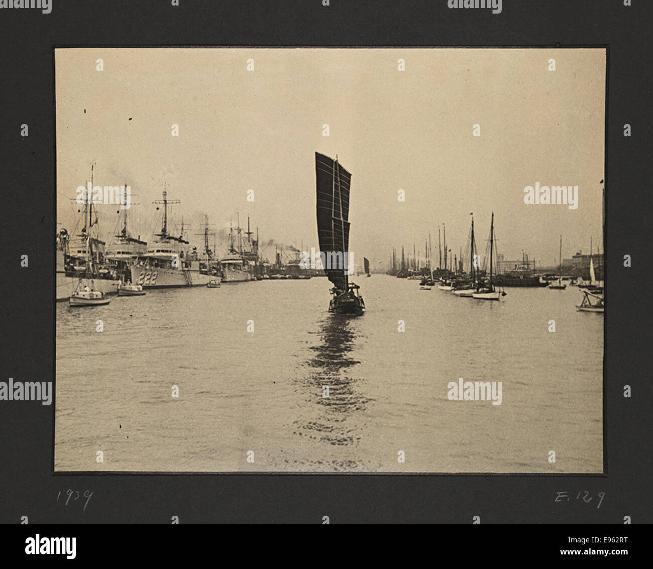 A photograph featuring a sampan alongside U.S. Navy warships and ...