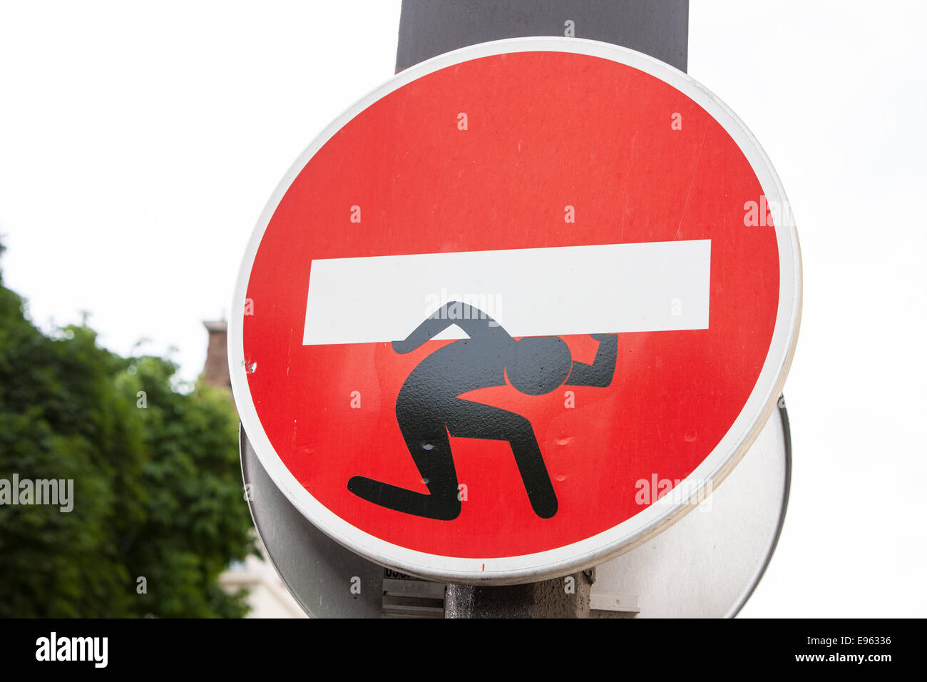 No entry road sign defaced in a humorous way to show a person carrying ...