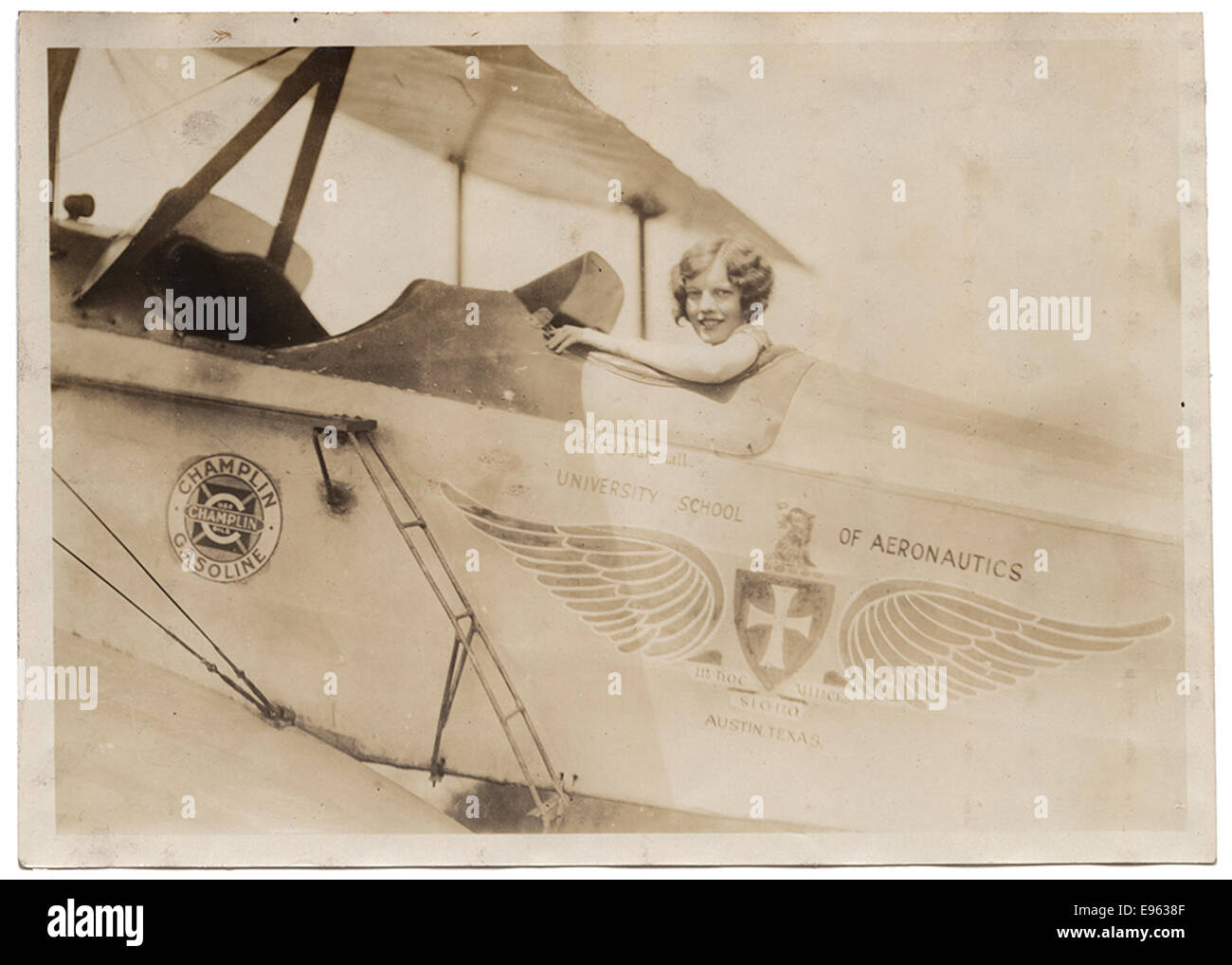 This photograph shows a woman in the cockpit of a biplane from the ...