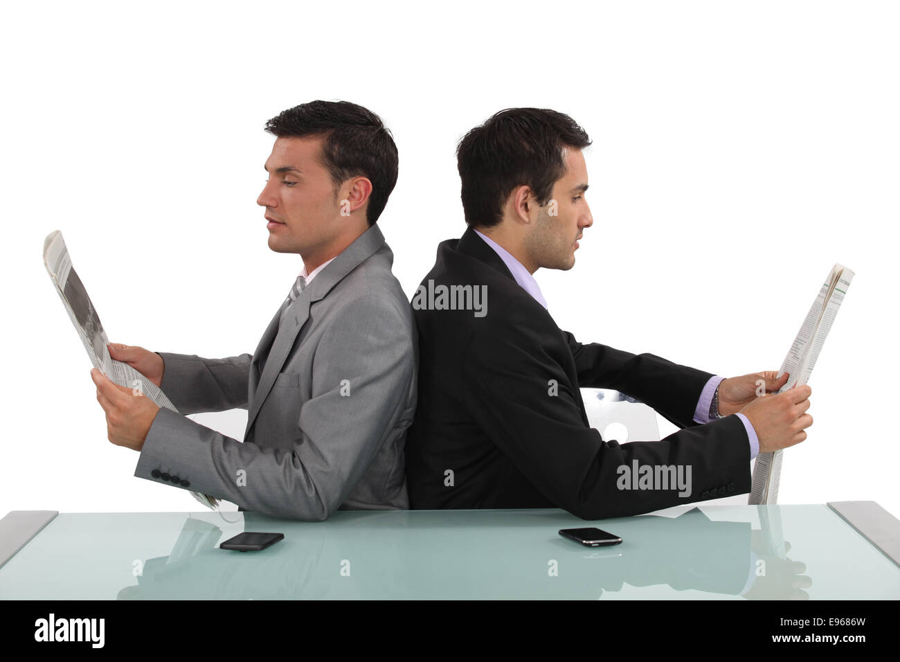 Two businessmen reading newspapers Stock Photo - Alamy