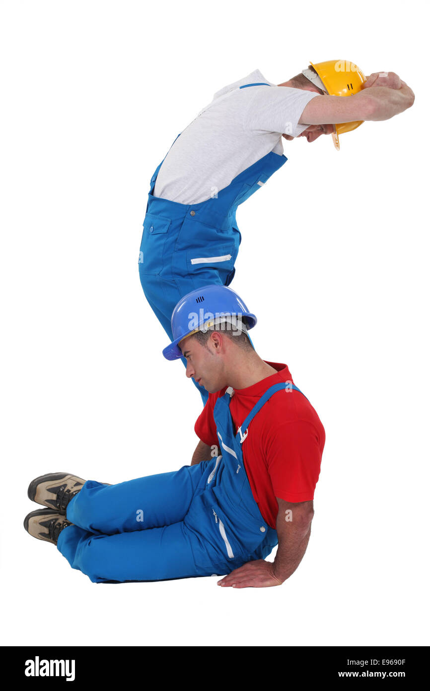 Two builders forming letter S Stock Photo - Alamy