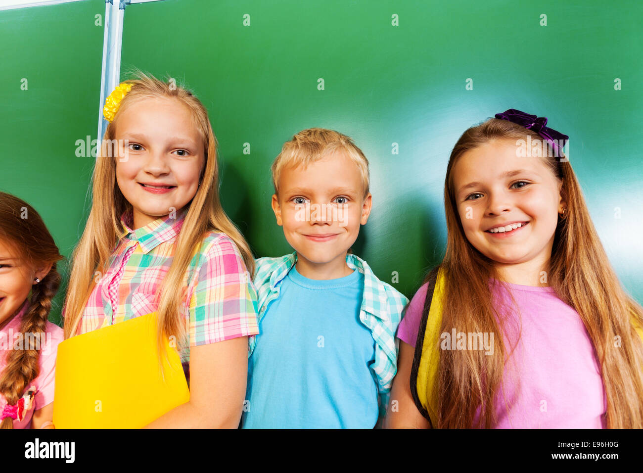 Three children stand together near blackboard Stock Photo - Alamy