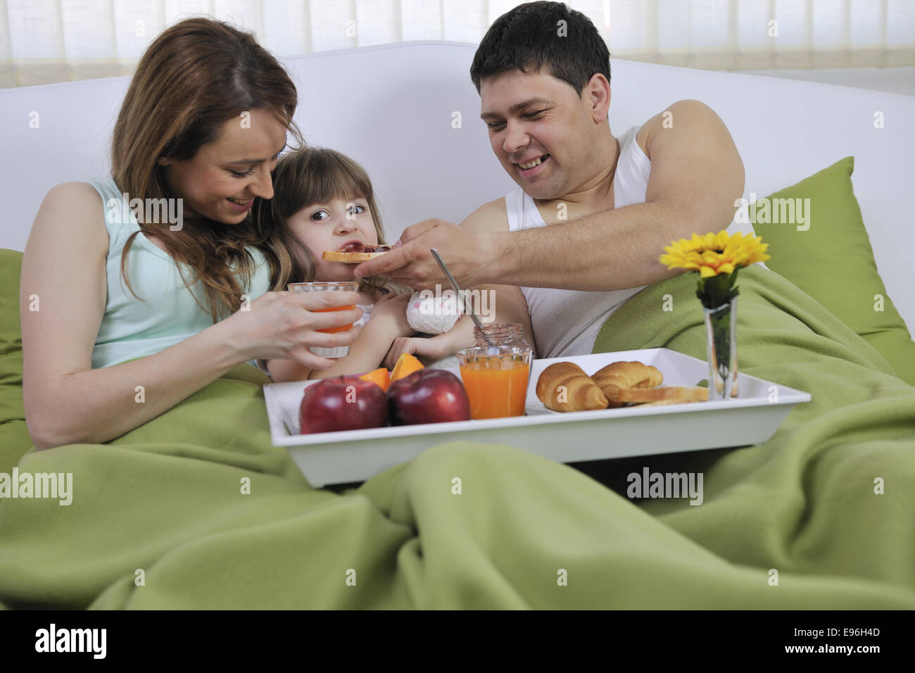 happy young family eat breakfast in bed Stock Photo - Alamy