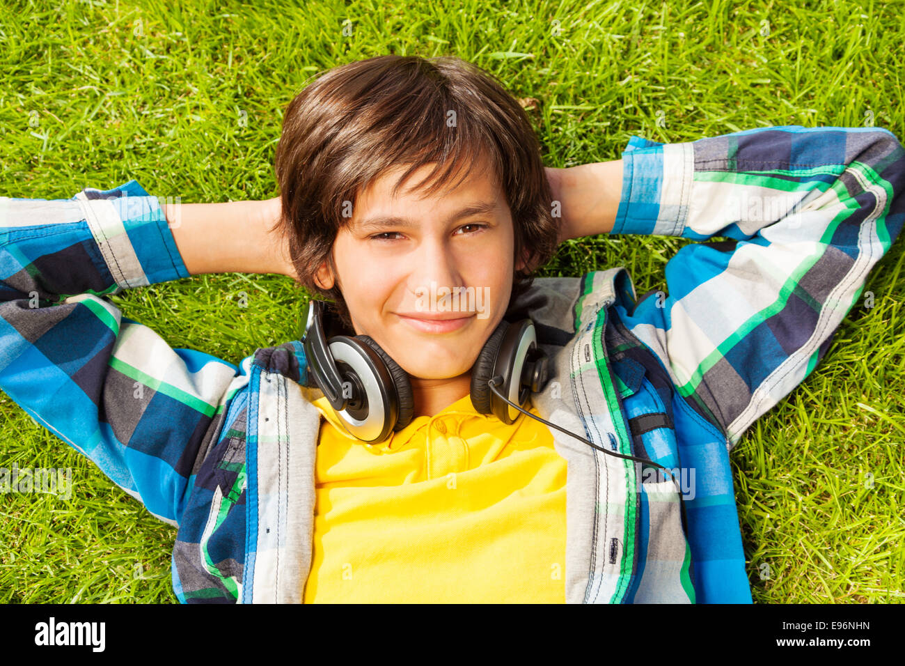 Smiling boy with arms under head Stock Photo - Alamy